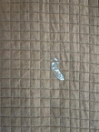 White, hard spill on bedspread that was removable with a damp cloth.