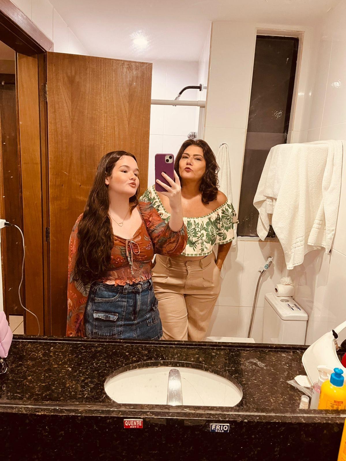 No banheiro do quarto, mãe e filha na preparação para curtir  a noite em Aracaju.
