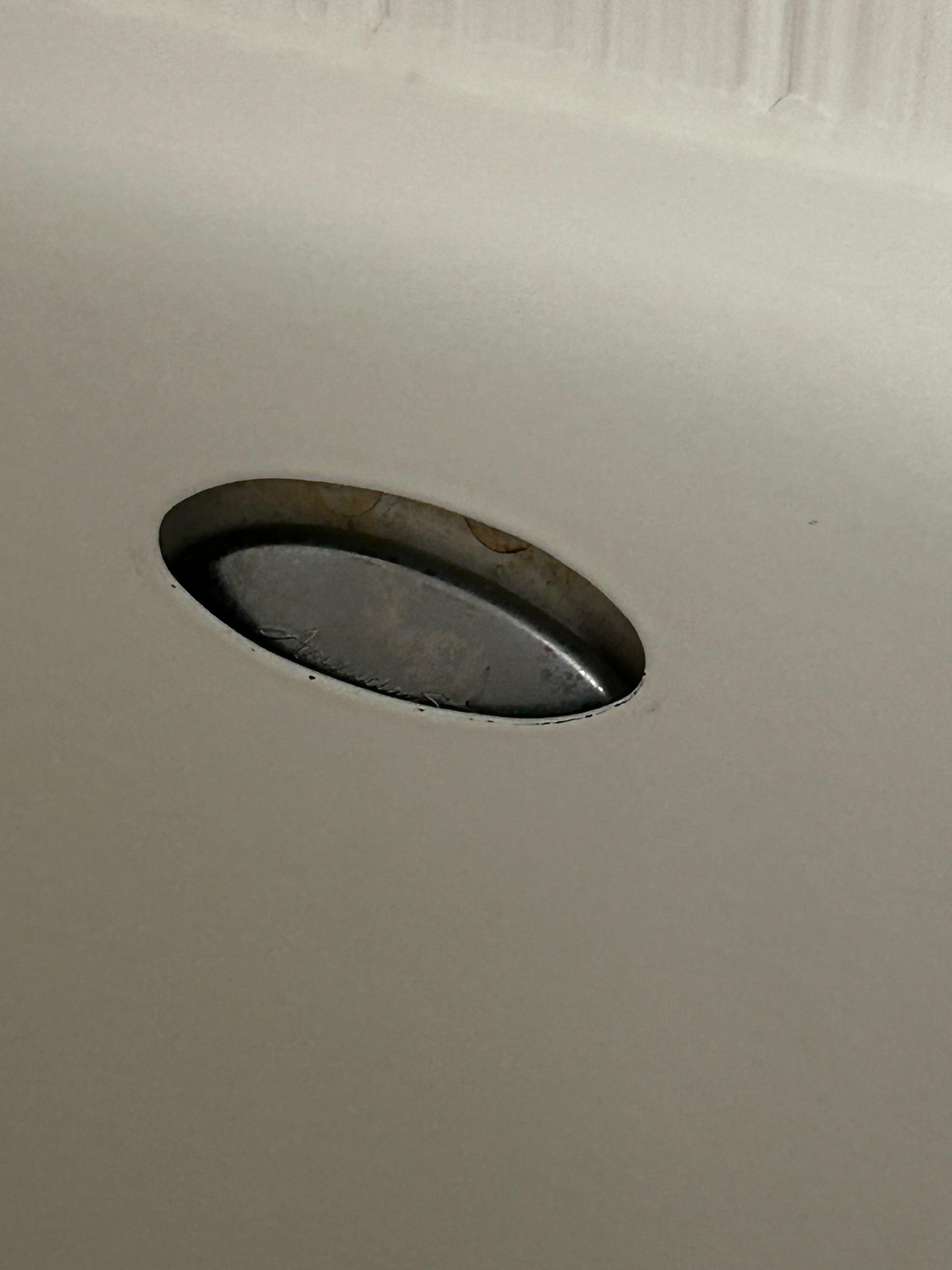 Drain plate cover behind the tub, leaving an open gap. 