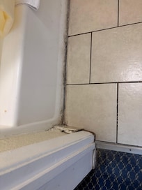 In even and loose tiles bold under silicone sealant. Rotted out wall paint chipping