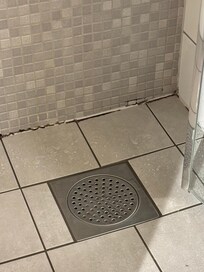 Veggen i dusjen bar preg av dårlig vedlikehold.