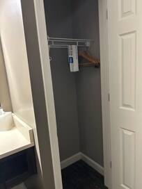 The closet has an iron and ironing board.