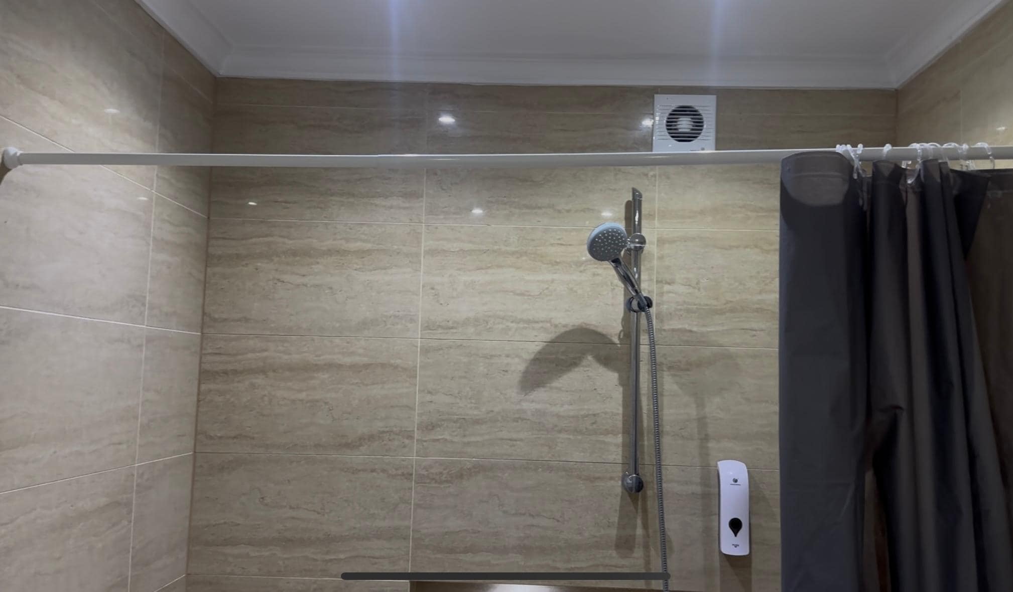 Wonky shower curtain and broken shower arm