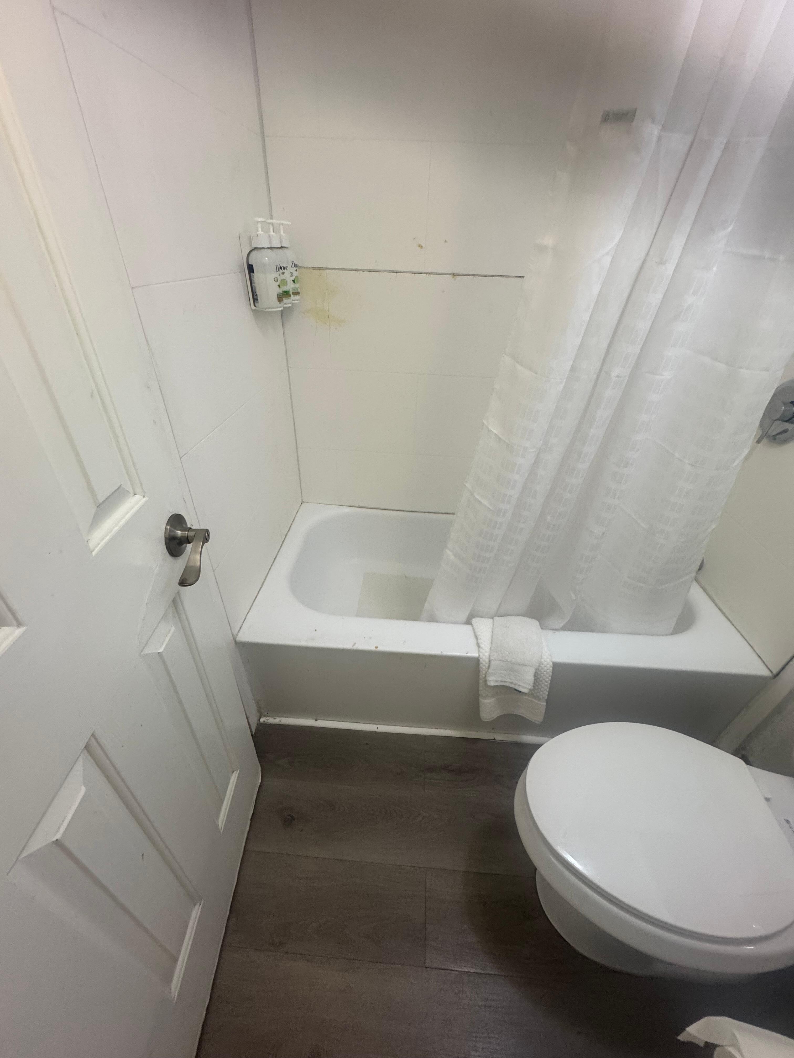 Yellow stains on walls and bathtub.