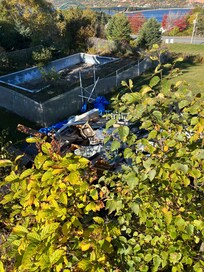 Pile of furniture and appliances dumped outside of room with pool used as a dump