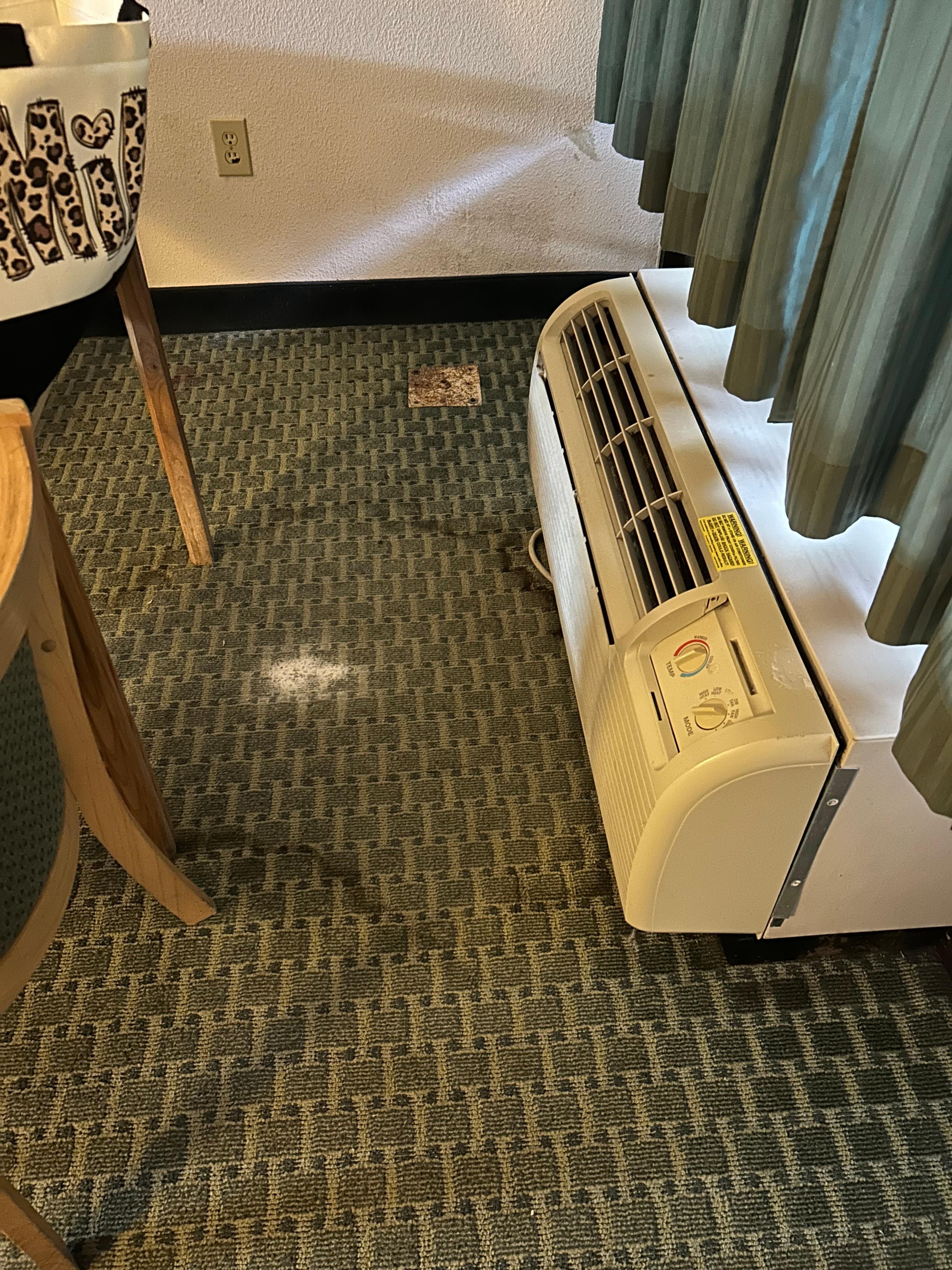 White substance and stains from ac. Table in the middle of floor and metal plate in the back corner where it looked as if a lamp was missing. 