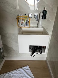 No shelf for toiletries or a towel rack, threw towel over shower door beside sink.