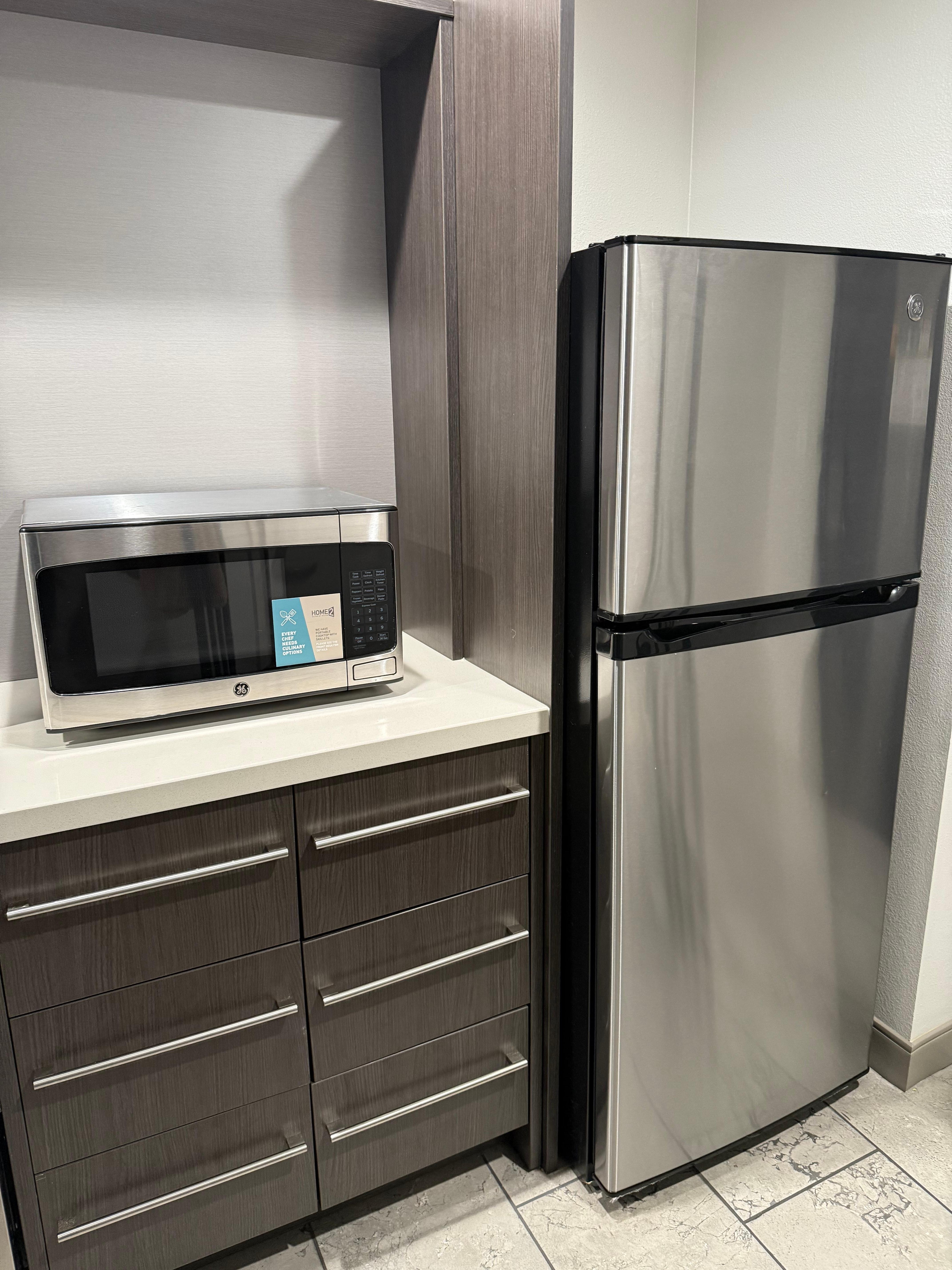 Kitchenette with microwave, refrigerator, dishwasher and dishes 
