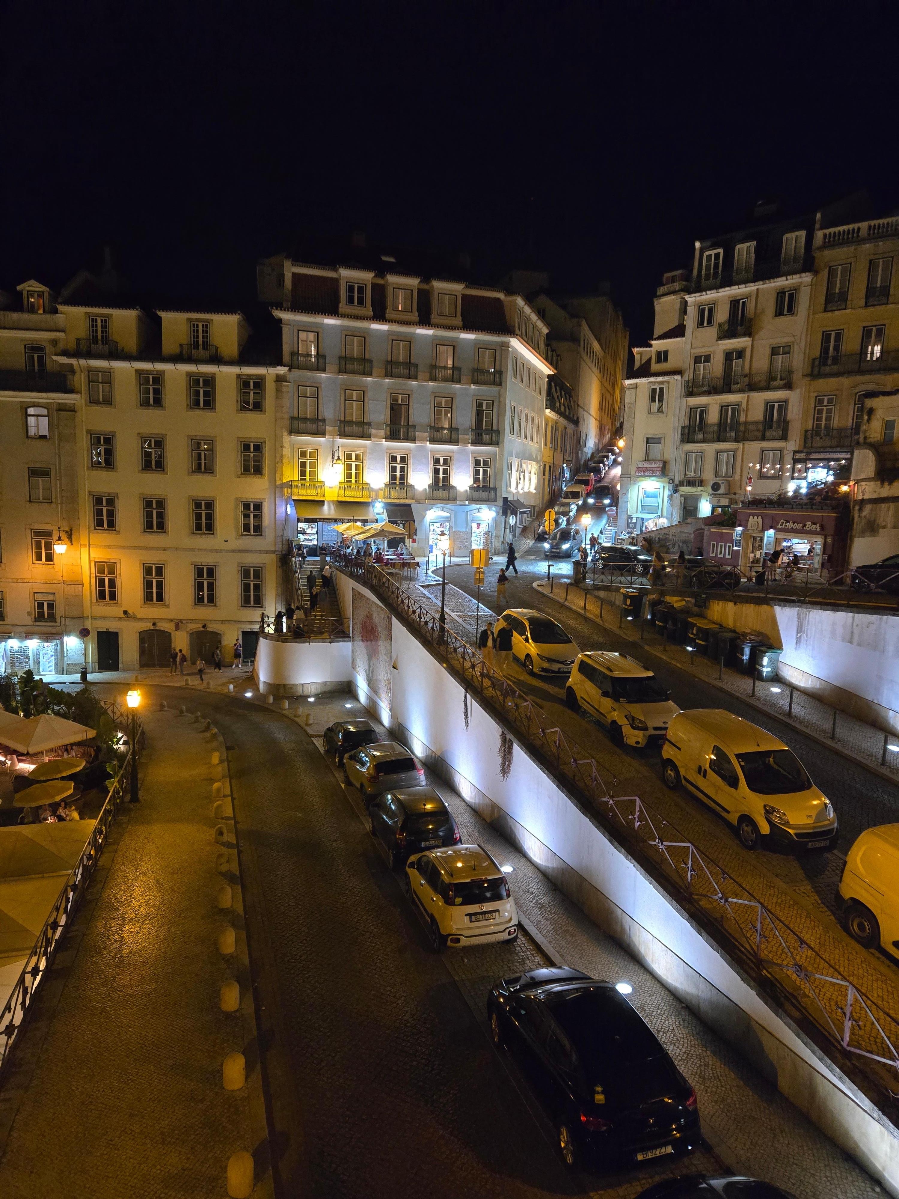 View of hotel from the 3rd floor entrance of the Rossio train station.  Hotel is in center of frame and the first floor is lit by bluish lights. 