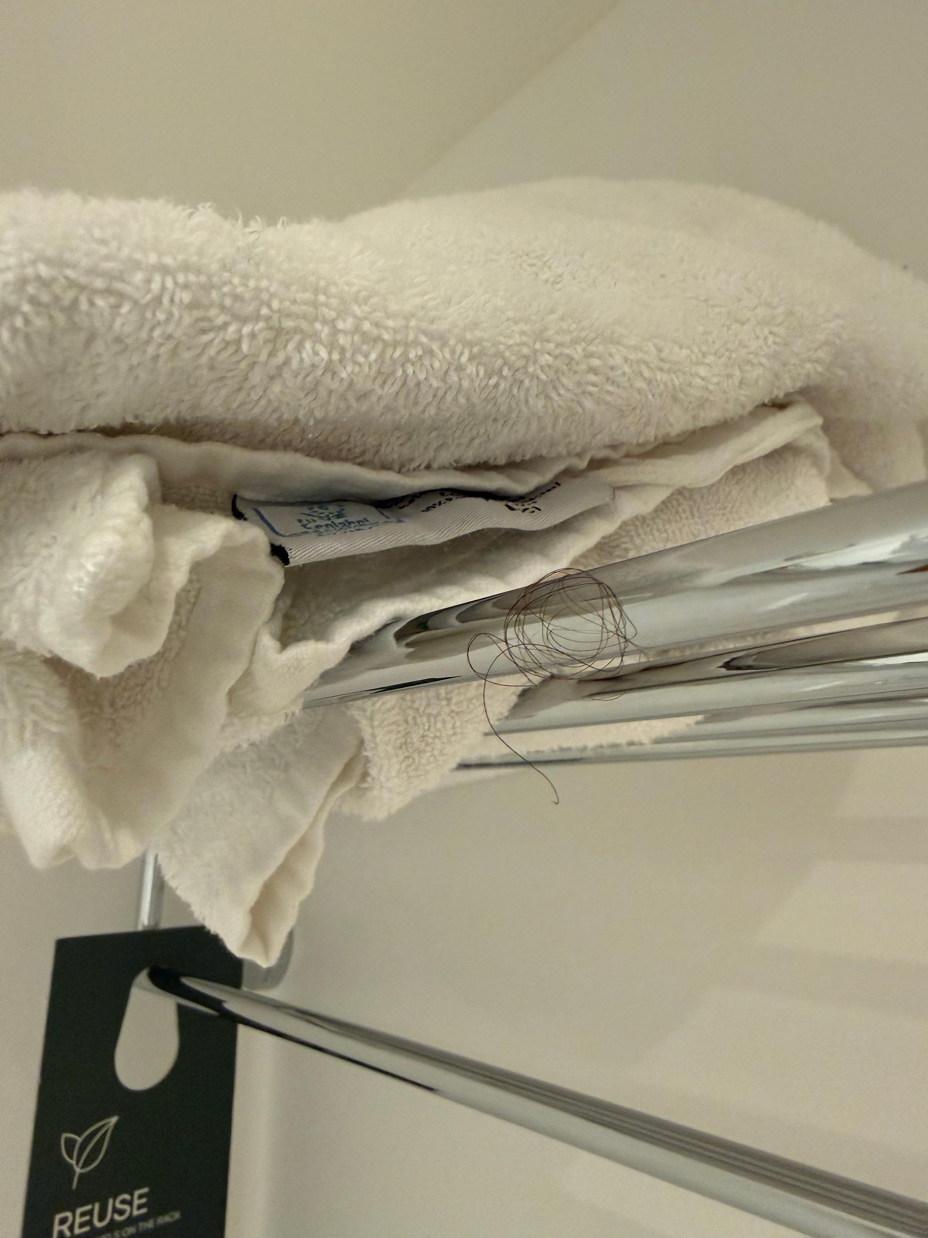 Hår der hænger ved håndklæderne. 