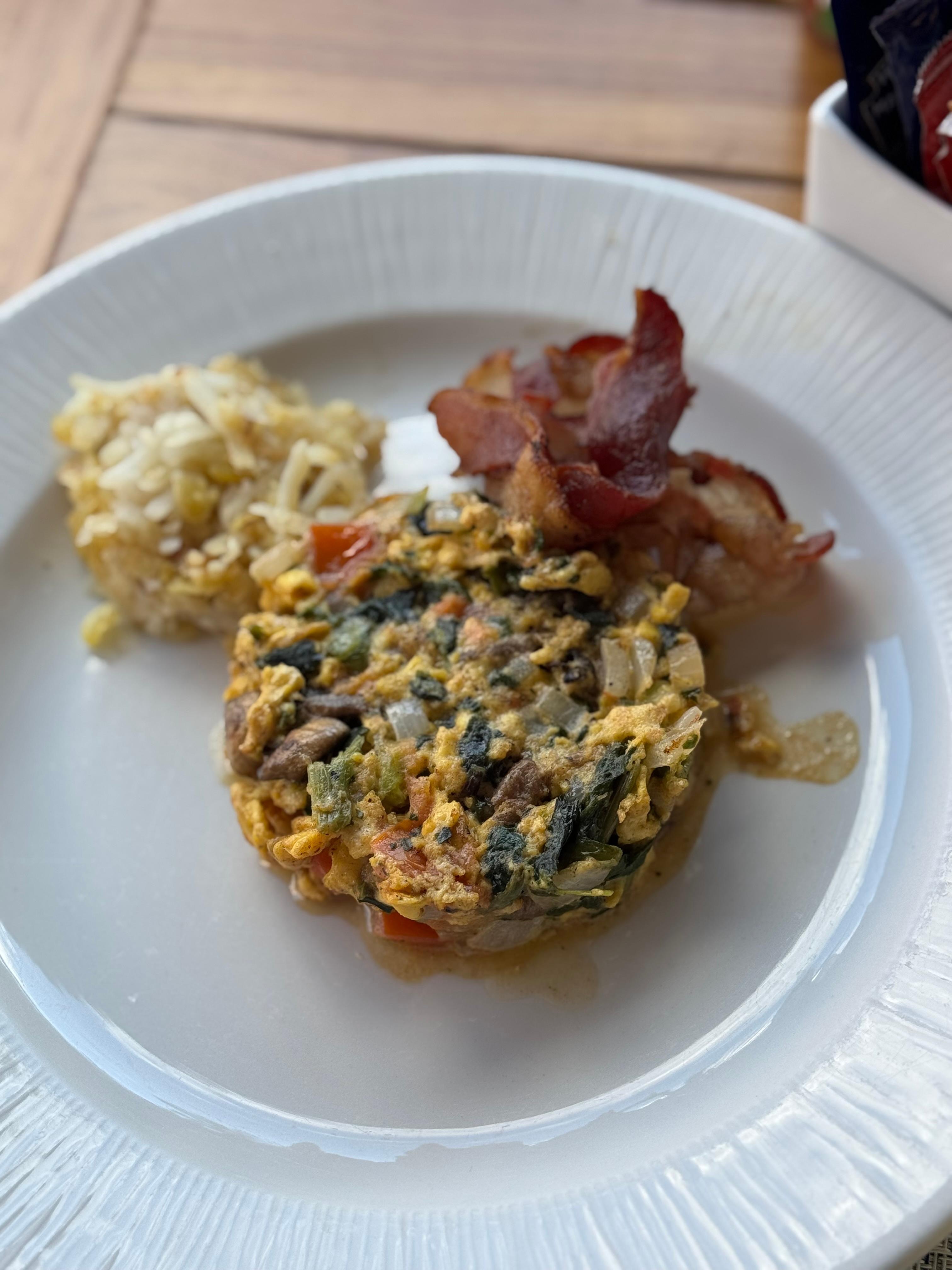 Egg Scrambled with choice vegetables, bacon, and potatoes 