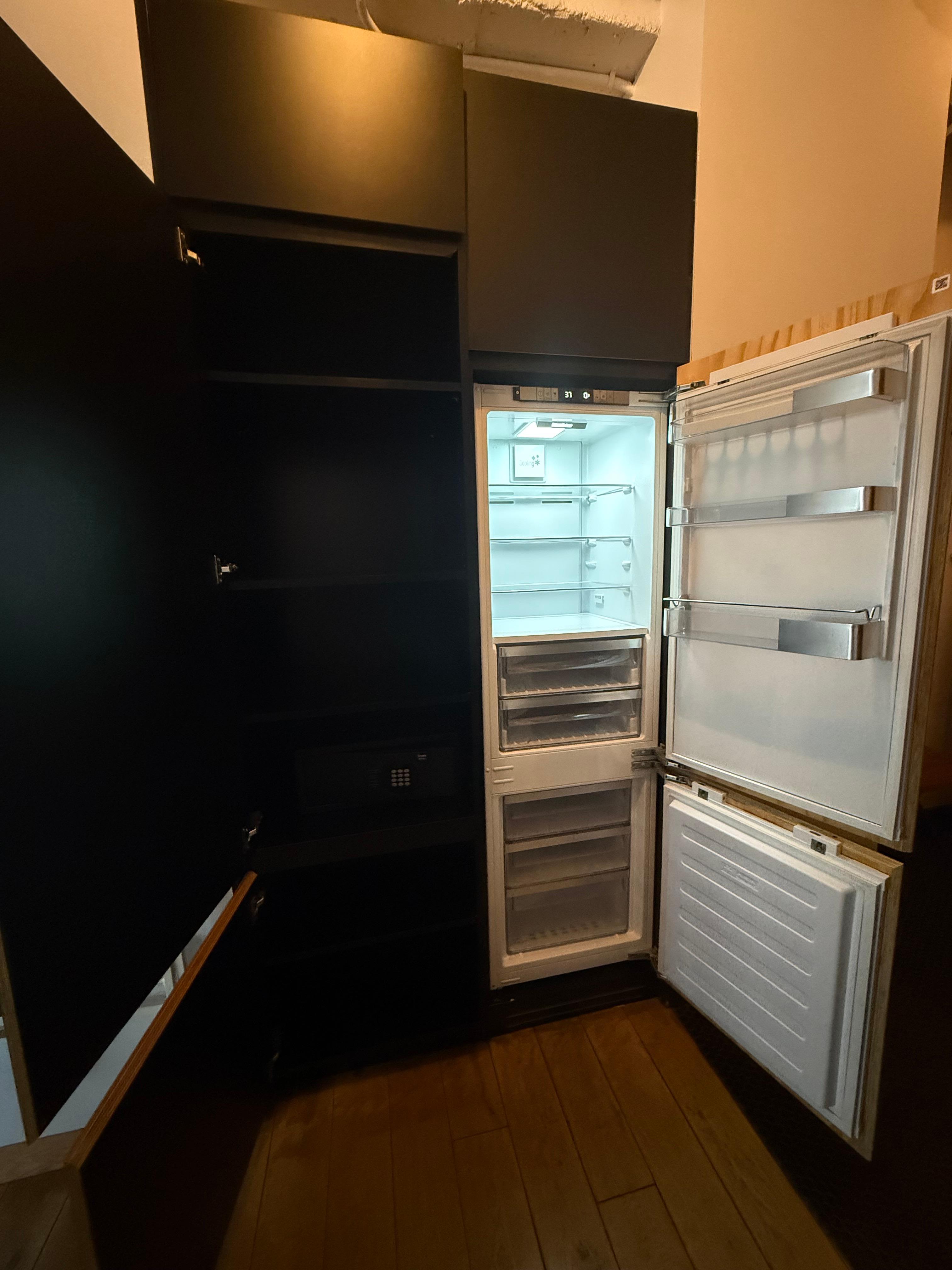 Cabinets with safe, fridge, and freezer.