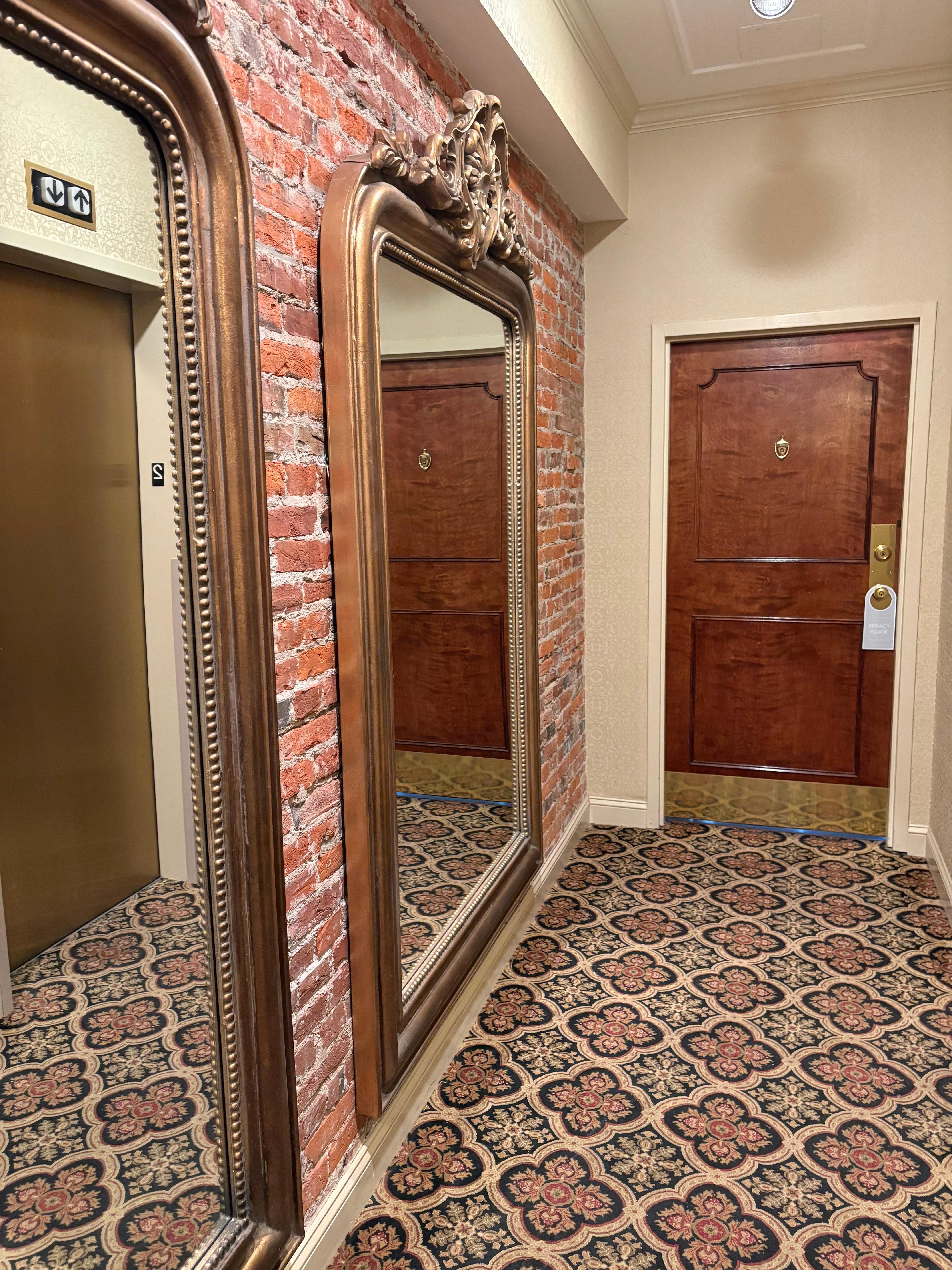 Love the brick walls and big mirrors in the hallway