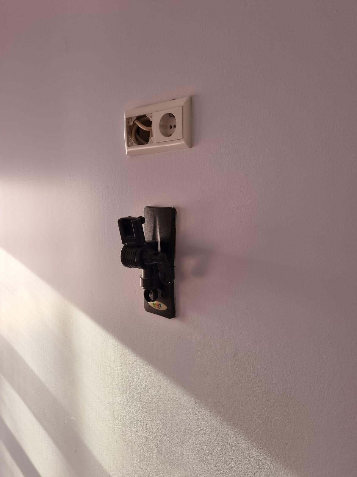 Parede com tomadas aparecendo (sem tv na sala).