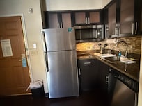 Room kitchen: full refrigerator with freezer, cooktop, sink & dishwasher plus dishes & cookware