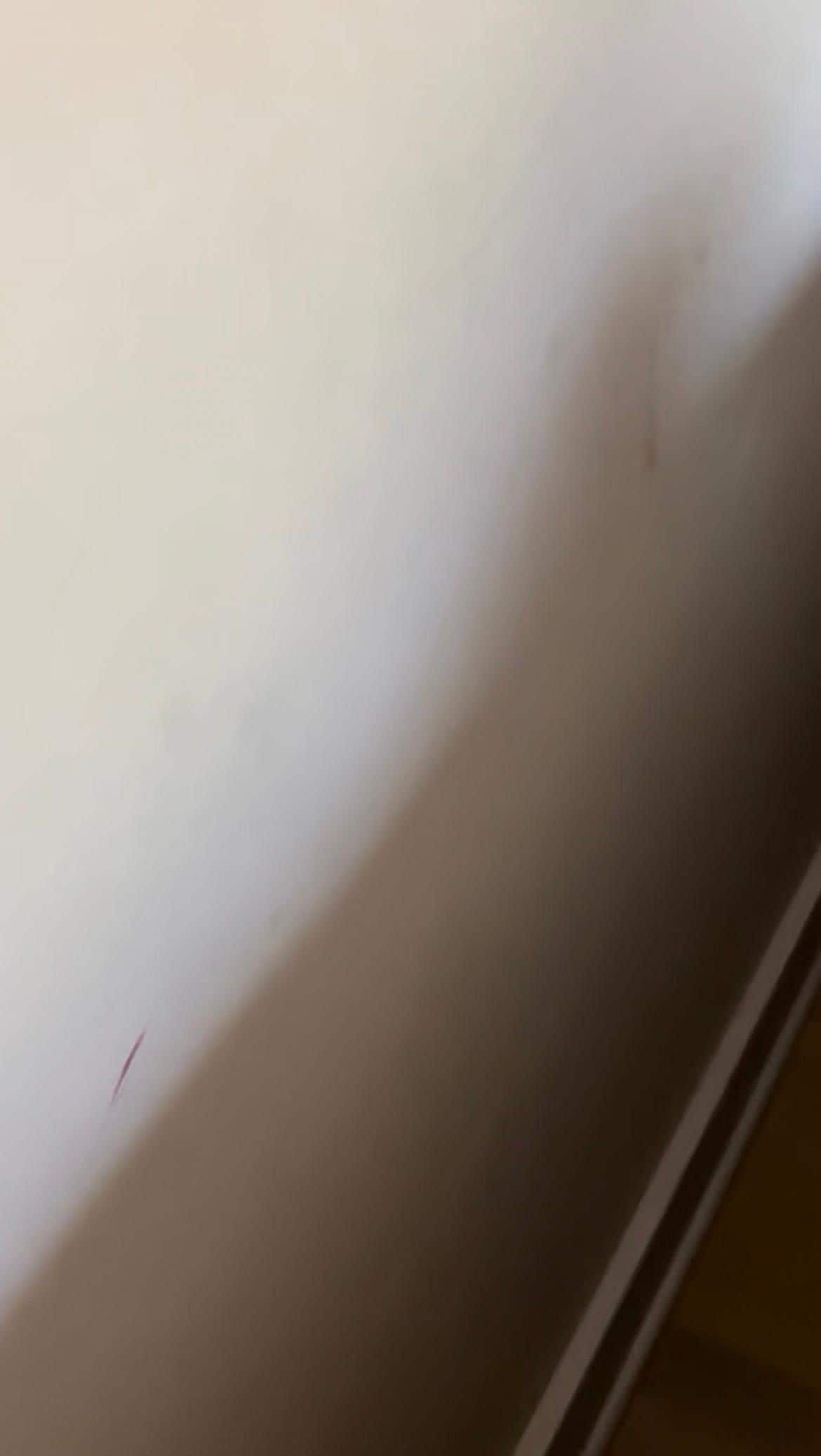 Dirty wall next to the bed. 
