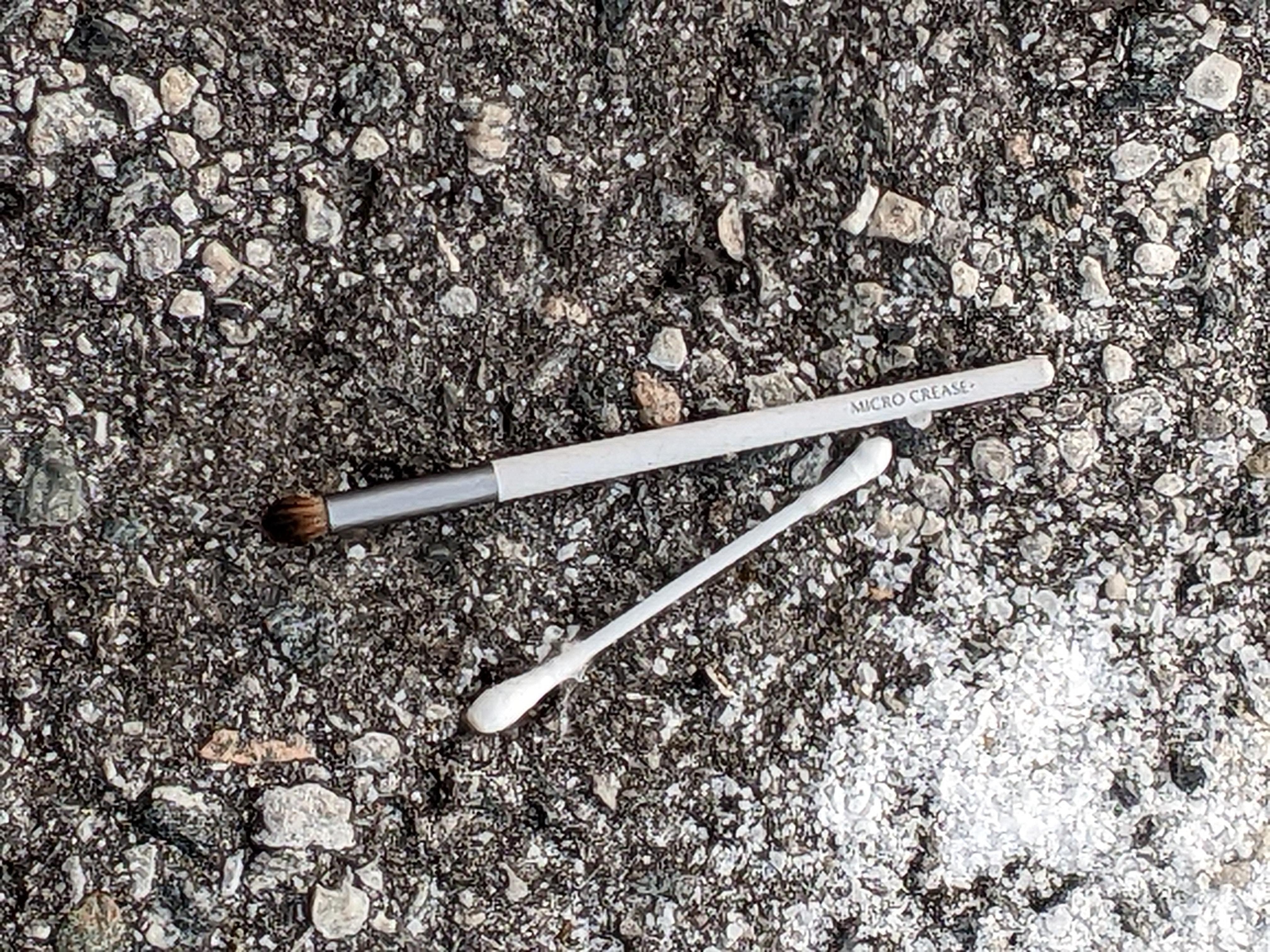 Appeared to be a syringe or some sort of smoking device with 50-75 q-tips and napkins scattered around the back side of the motel.