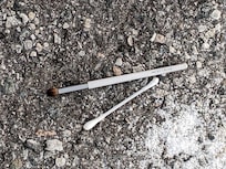 Appeared to be a syringe or some sort of smoking device with 50-75 q-tips and napkins scattered around the back side of the motel.