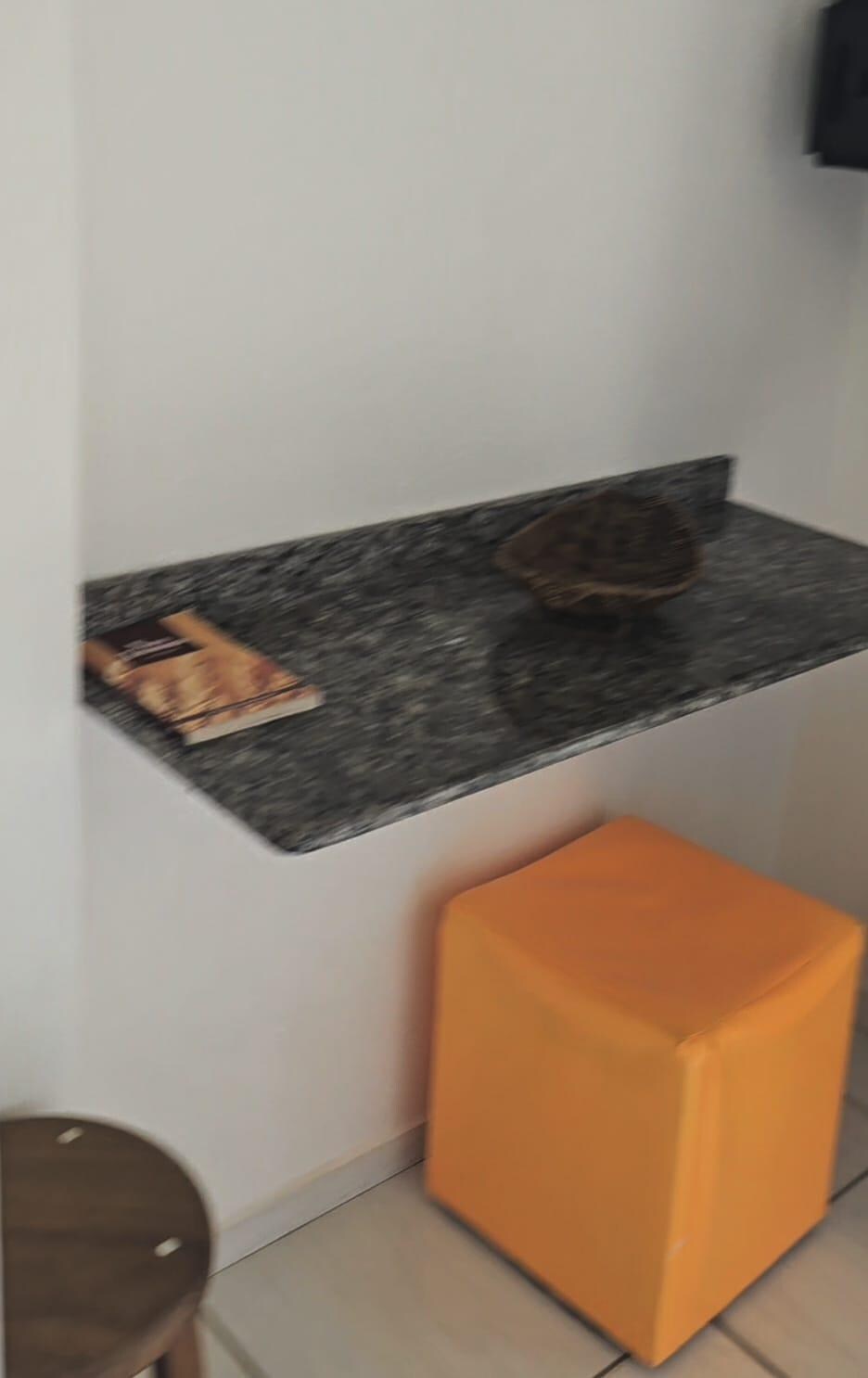 Banco laranja afundando o tampo, não sendo possível sentar