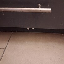 Dirt,hair and lint stuck to bottom of bathroom cabinet