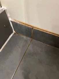 Bathroom grout so dirty that towel laid over picked up brown stain stripes