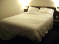 A comfy double bed with two bedside lamps.