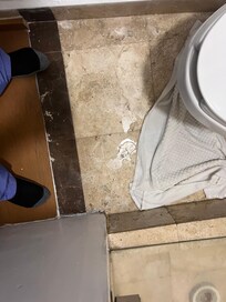 Wet floor and prior repair where tile used to be.