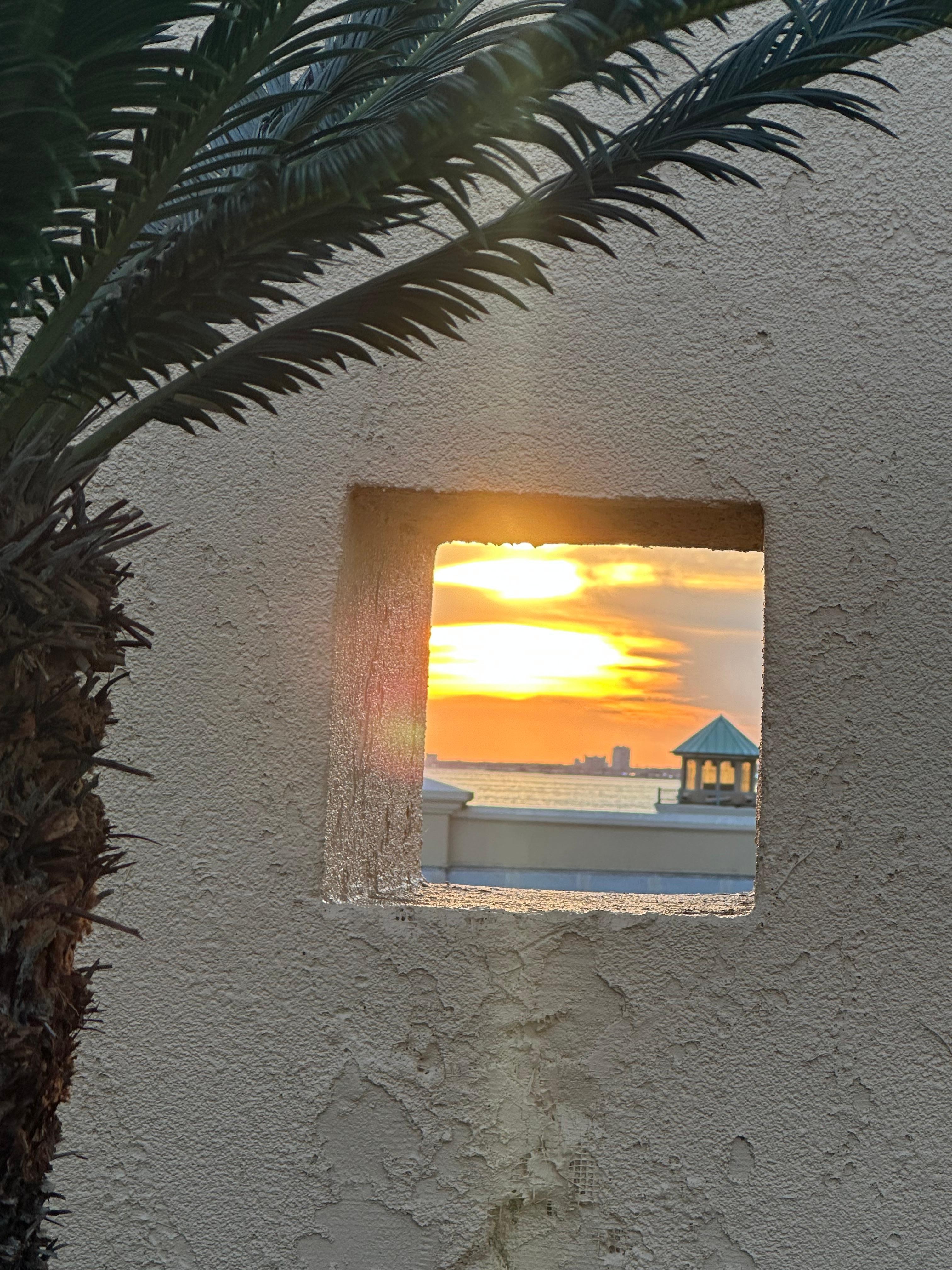 Sunset through the wall on the tanning patio by the Beau Rivage pool 