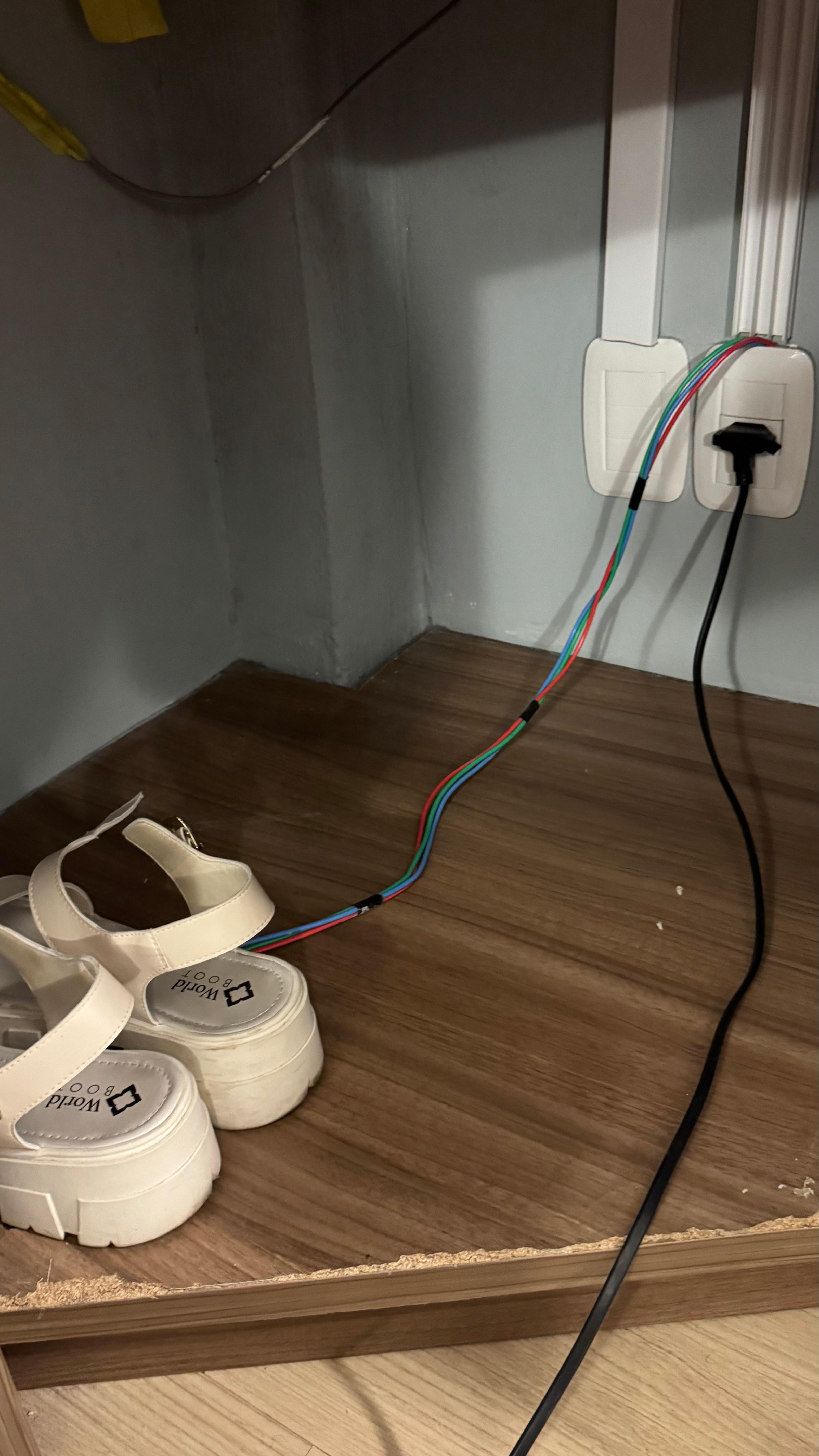 Fios expostos do ar condicionado e do frigobar. 