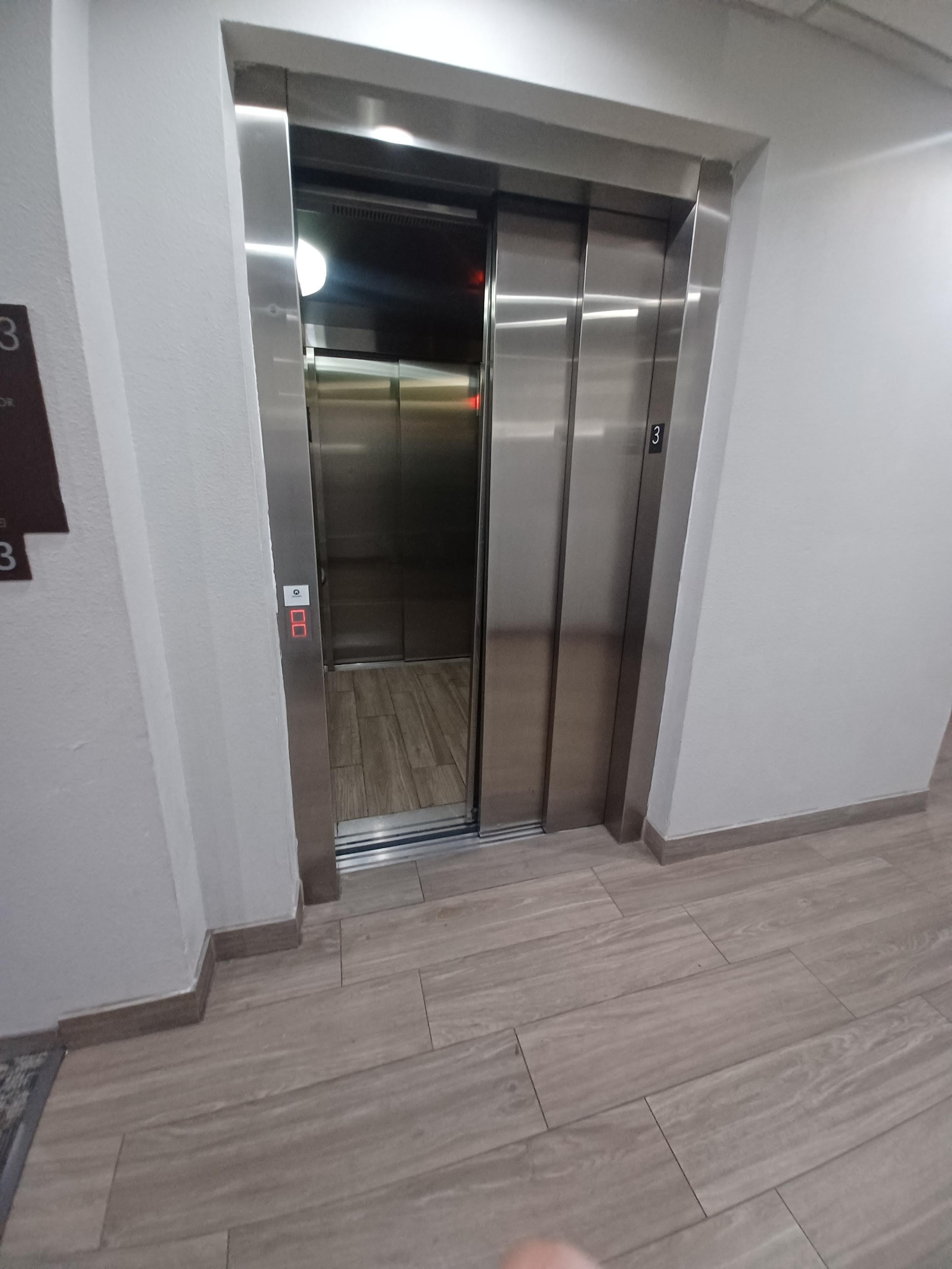Photo of elevator broken and sitting on 3rd floor
