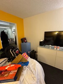 The space between the fridge and dresser is the only space that you’re able to put your luggage and the view to the bathroom vanity.