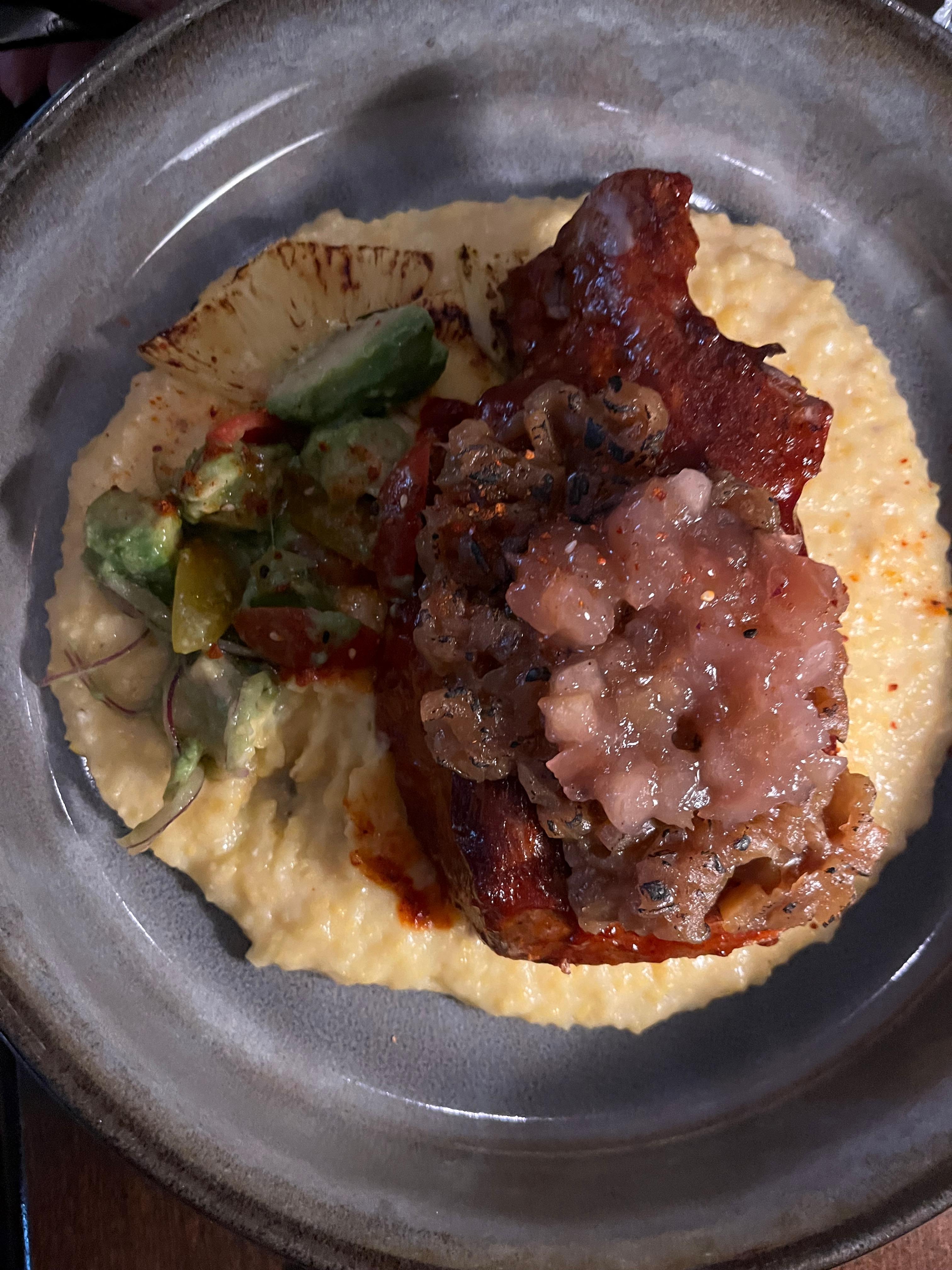 Pork chop all pastor with pineapple pico de gallo on cheesy grits