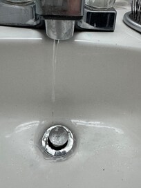 Drizzle of water in the bathroom sink