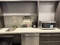 Kitchenette with microwave, refrigerator, dishwasher and dishes
