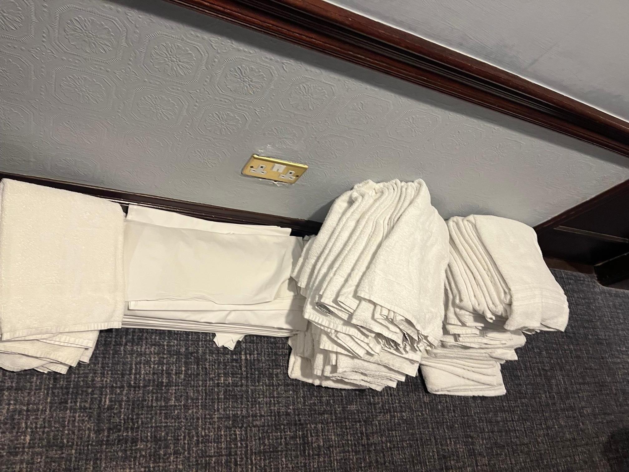 Towels and bedding stored on corridor floor