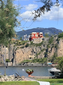 The rust colored building on the cliff.