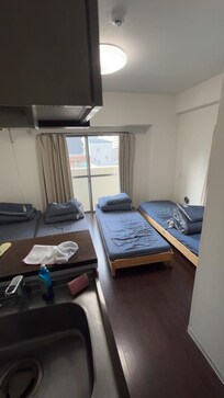 Dark flooring and kitchen cabinetry with squeaky bed frames with denim bedding! Cramped space for family of 4.